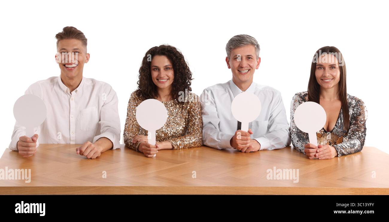 Panel of happy judges with blank score signs at table on white ...