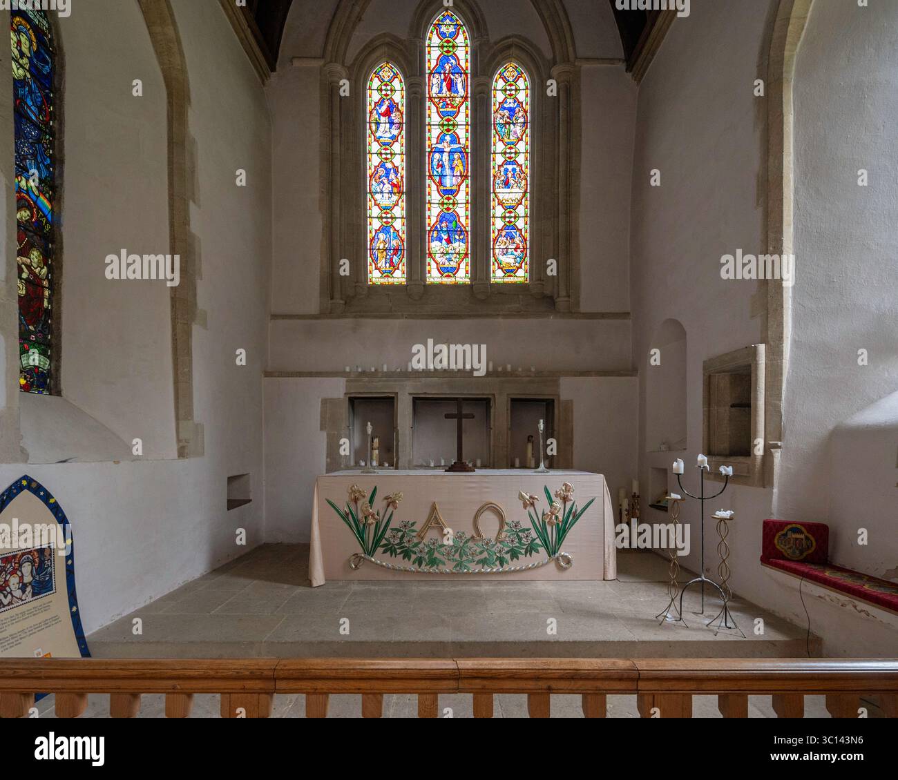 The altar and 13th century stained glass window in the 11th century St ...