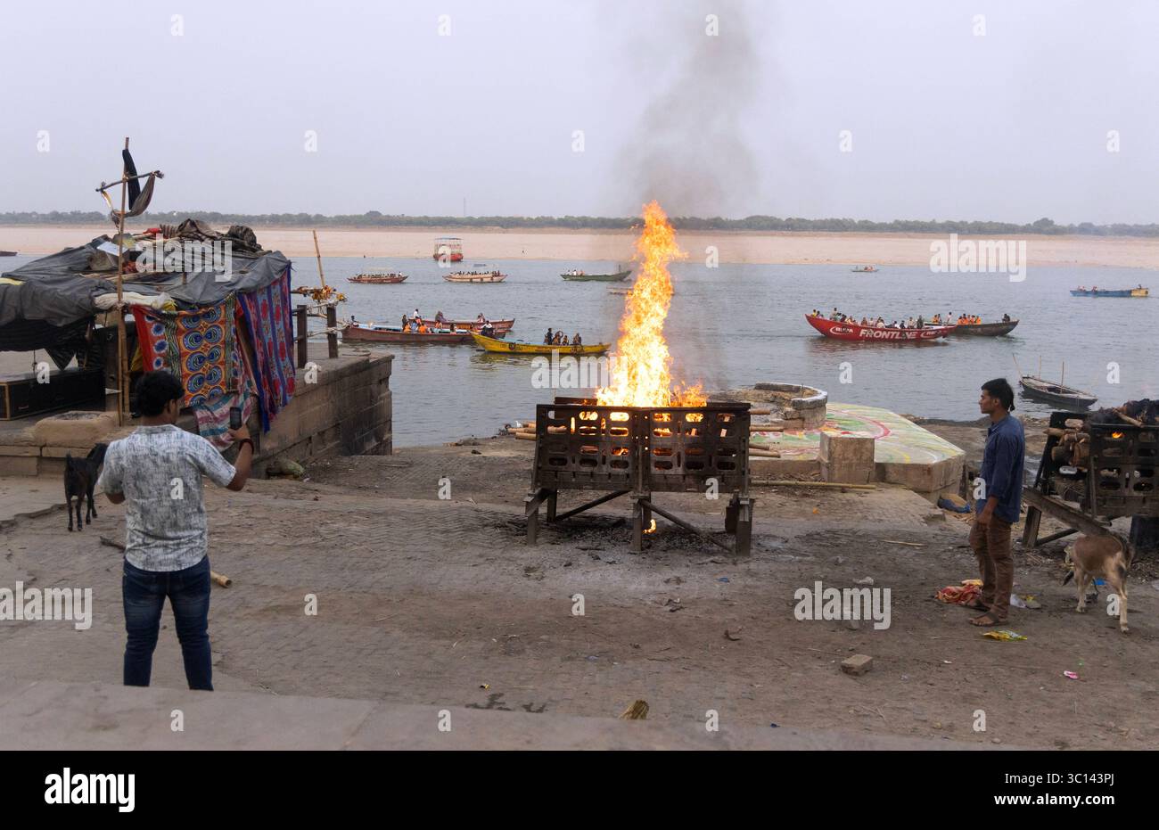 Funeral traditions and pollution at Manikarnika Ghat, in India Men stand near a funeral pyre as ...
