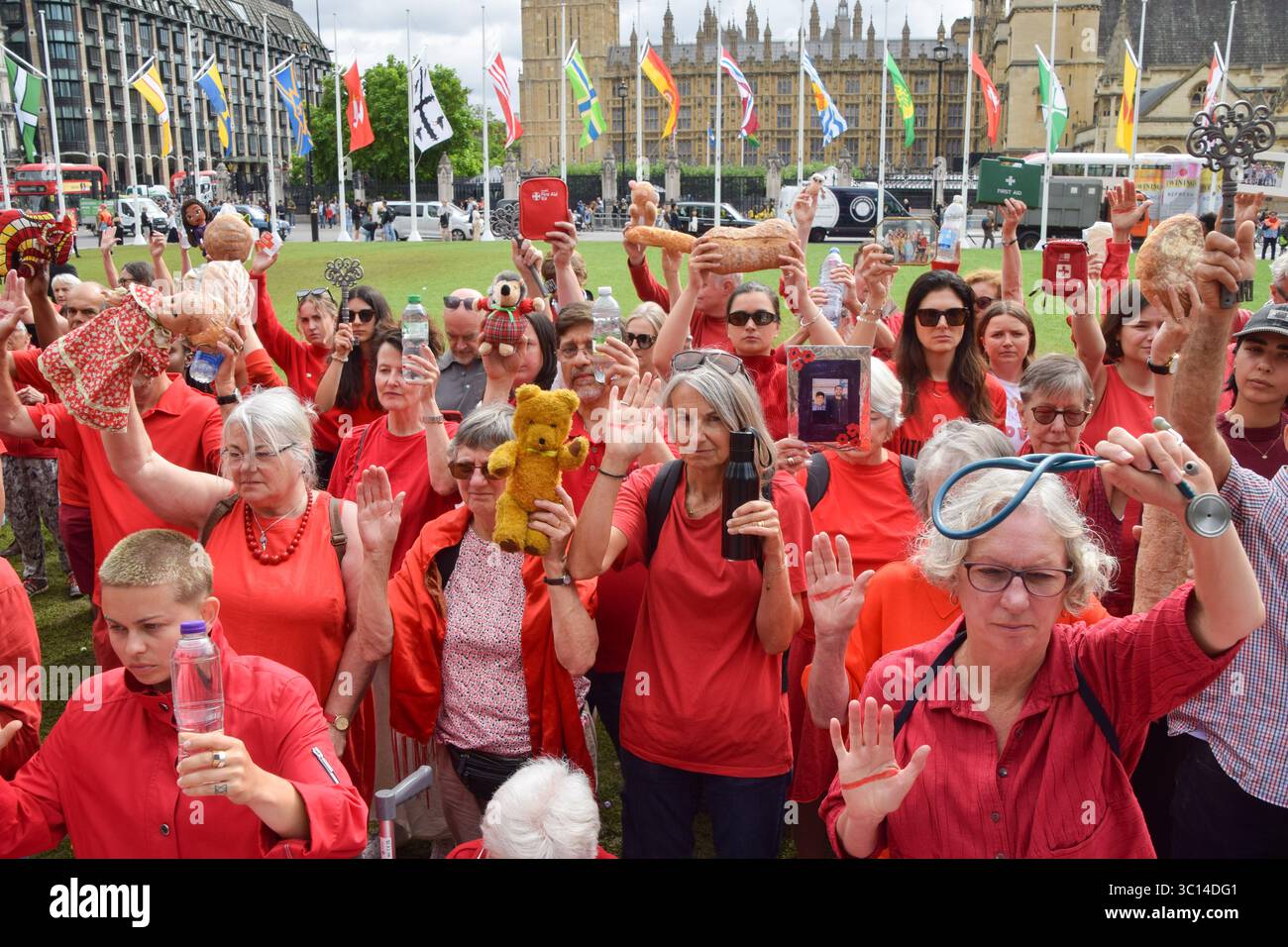Protesters hold up first aid kits, bread, water, toys and various other ...