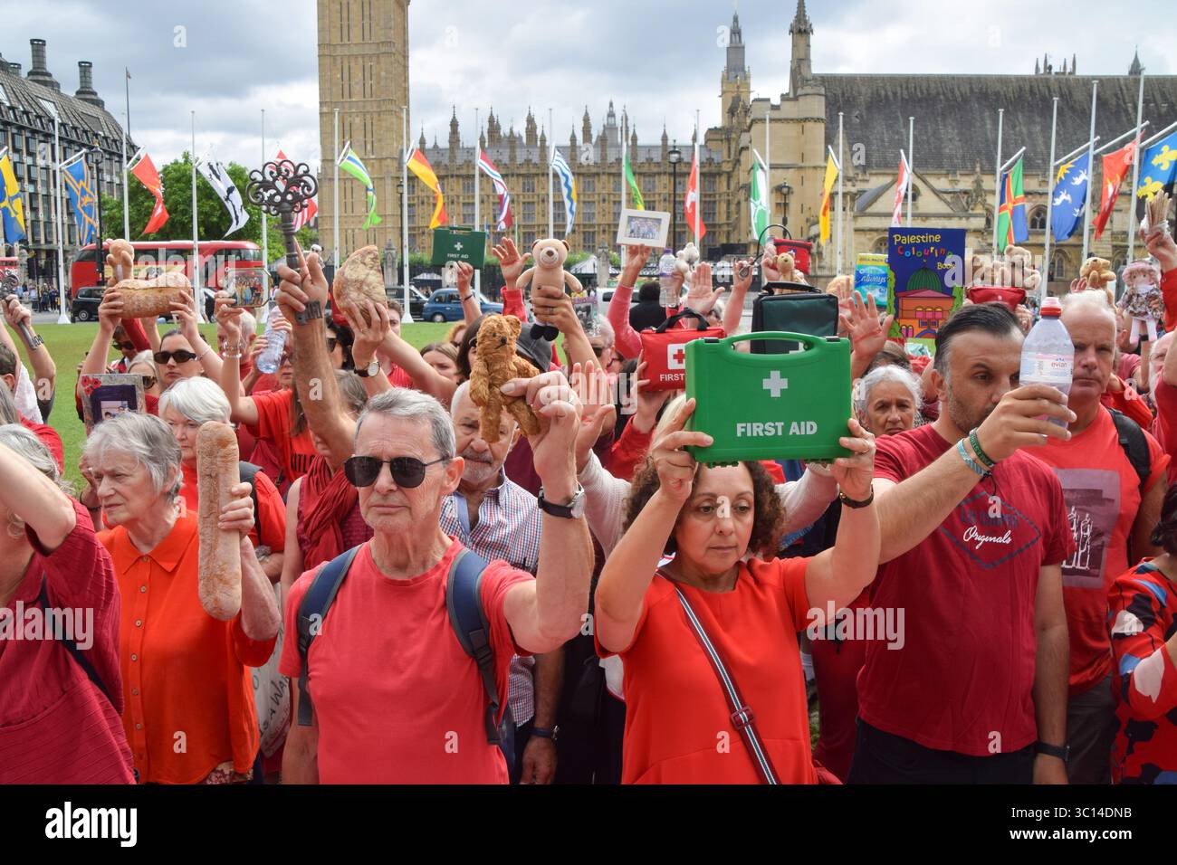 Protesters hold up first aid kits, bread, water, toys and various other ...