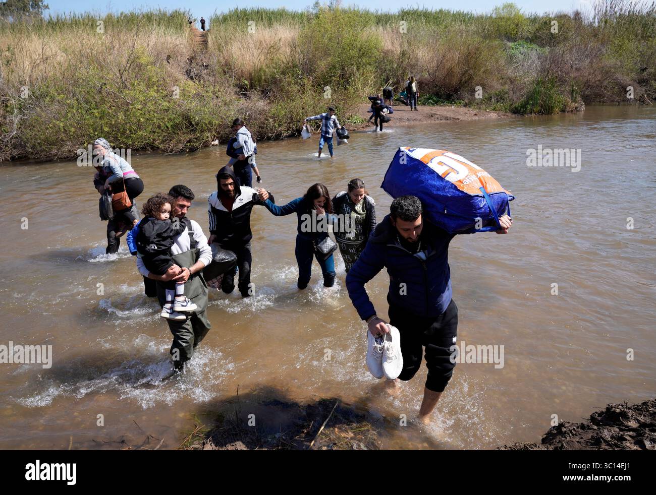 FILE - Syrian Alawite families who fled the clashes in Syria carry ...