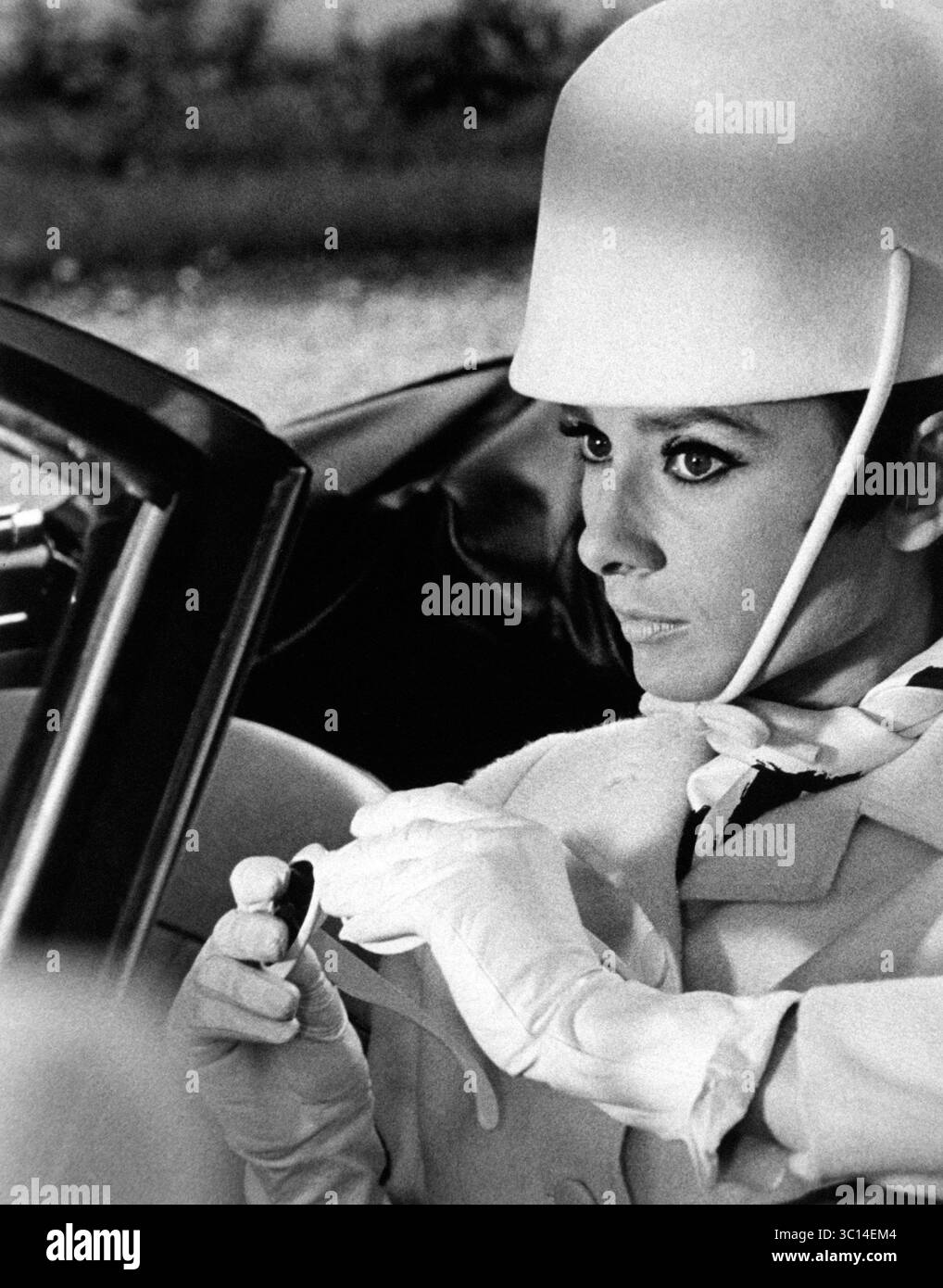 British actress Audrey Hepburn, wearing white hat, gloves and suit ...