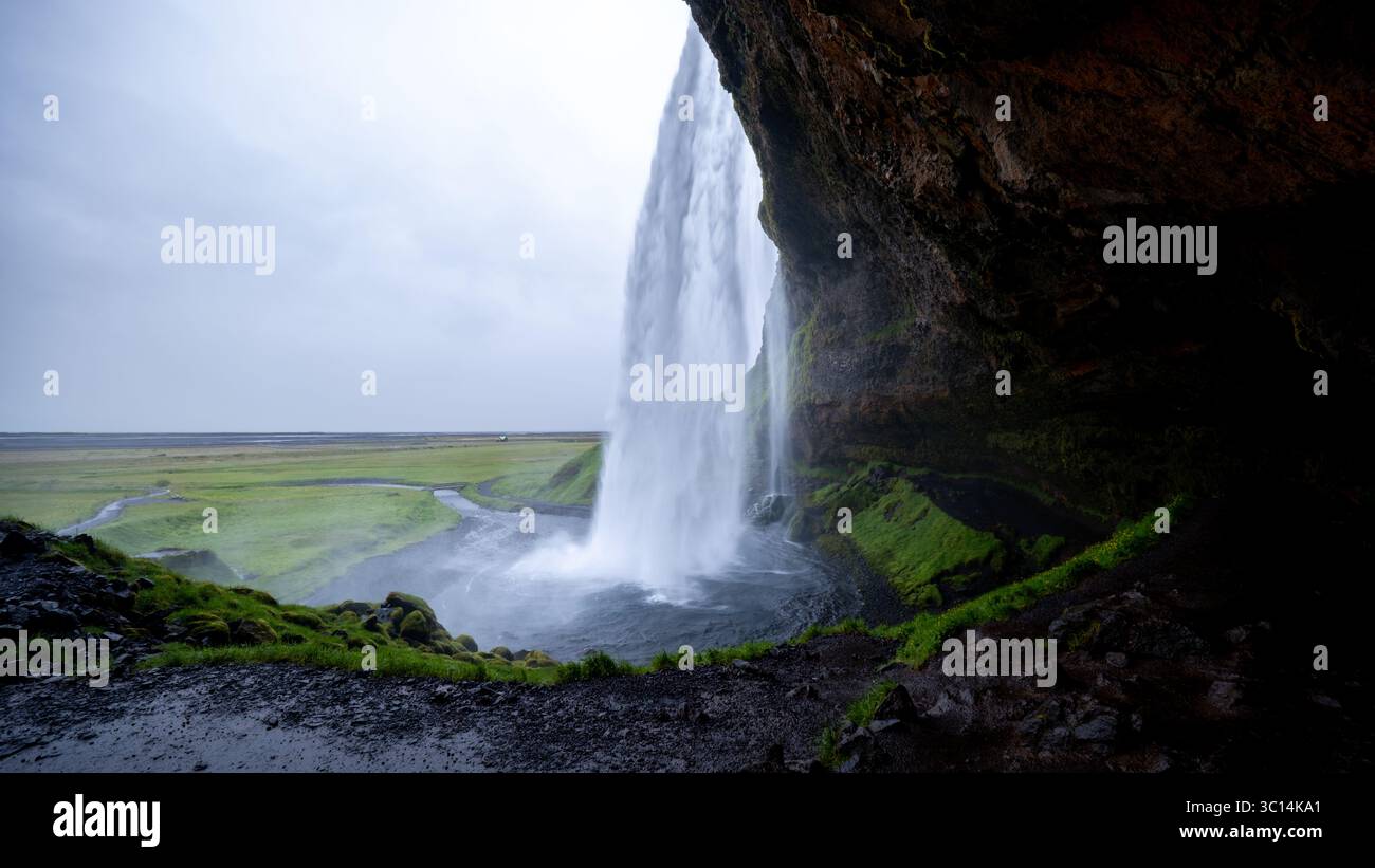 Water cascades dramatically from the Seljalandsfoss waterfall ...