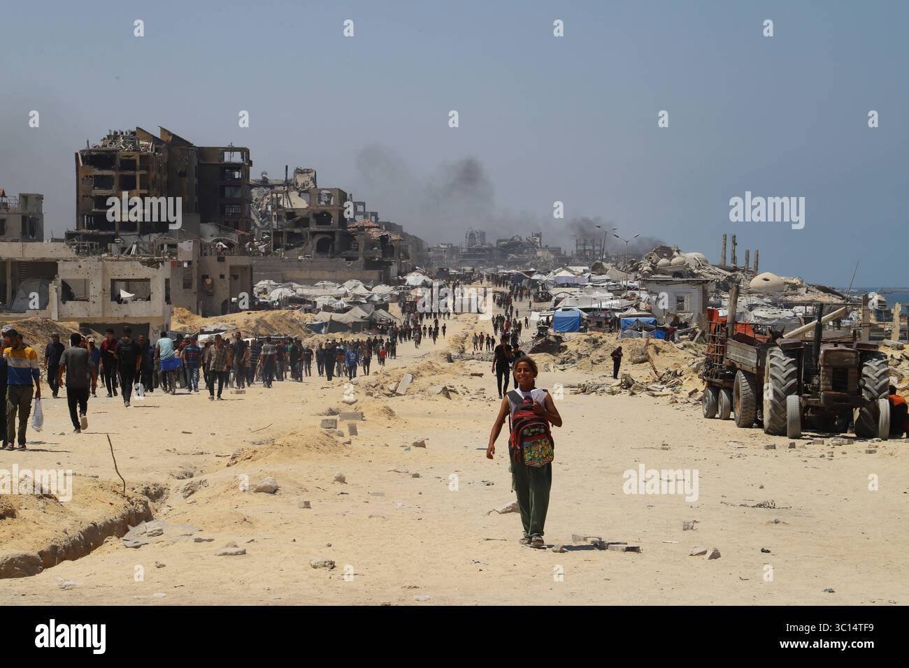 People make their way along al-Rashid street in western Jabalia People ...