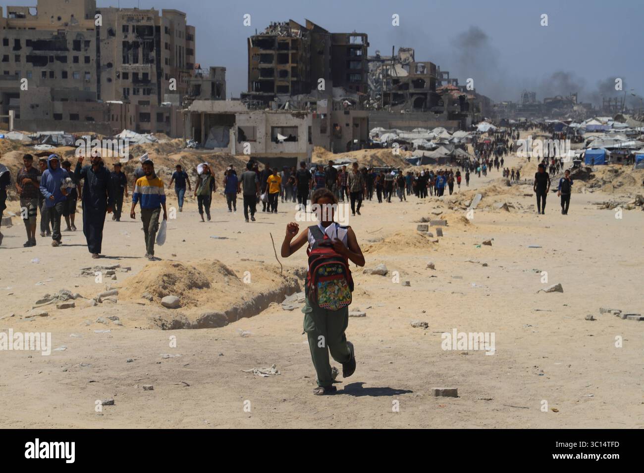 People make their way along al-Rashid street in western Jabalia People ...