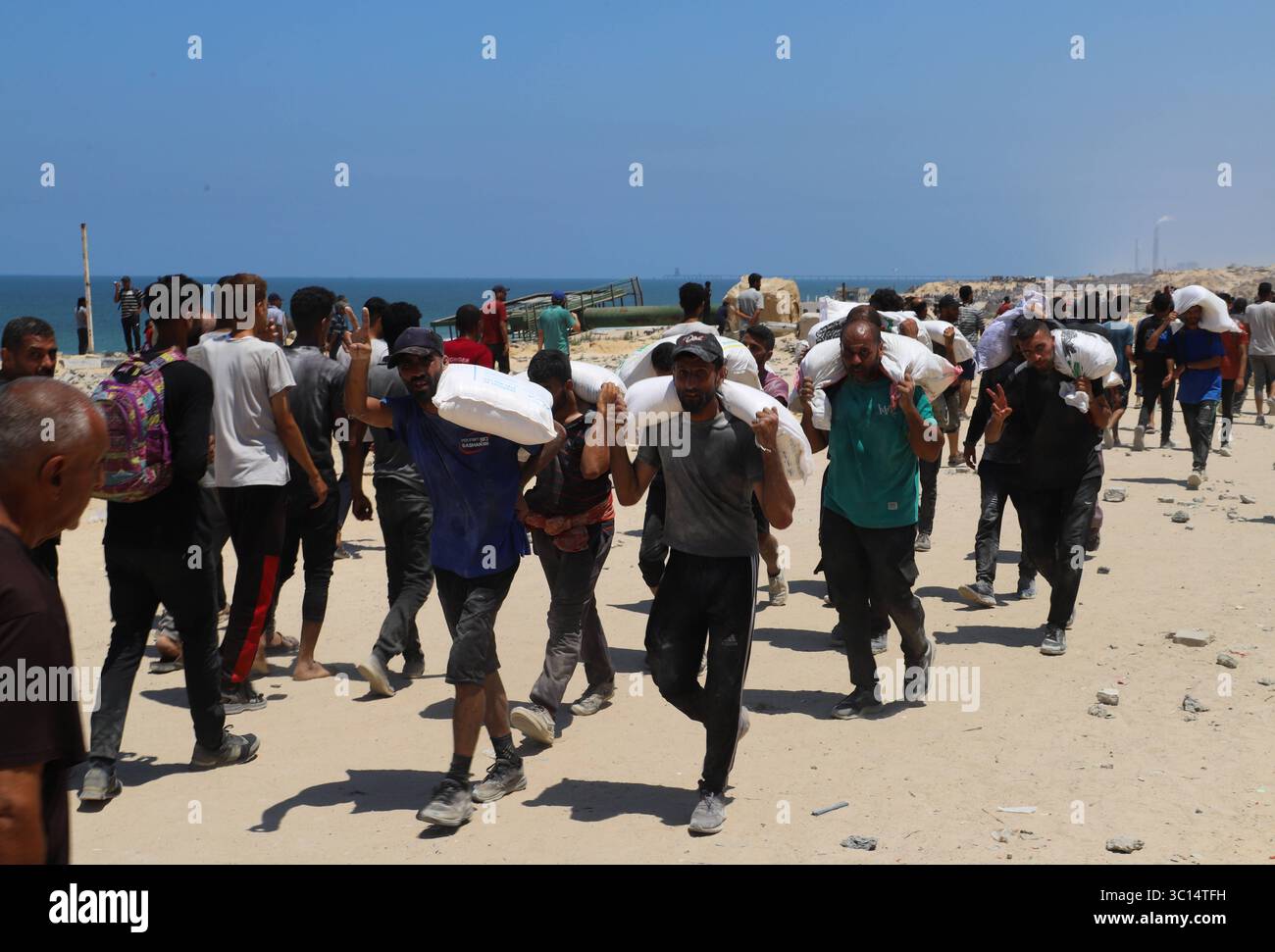 People make their way along al-Rashid street in western Jabalia People ...