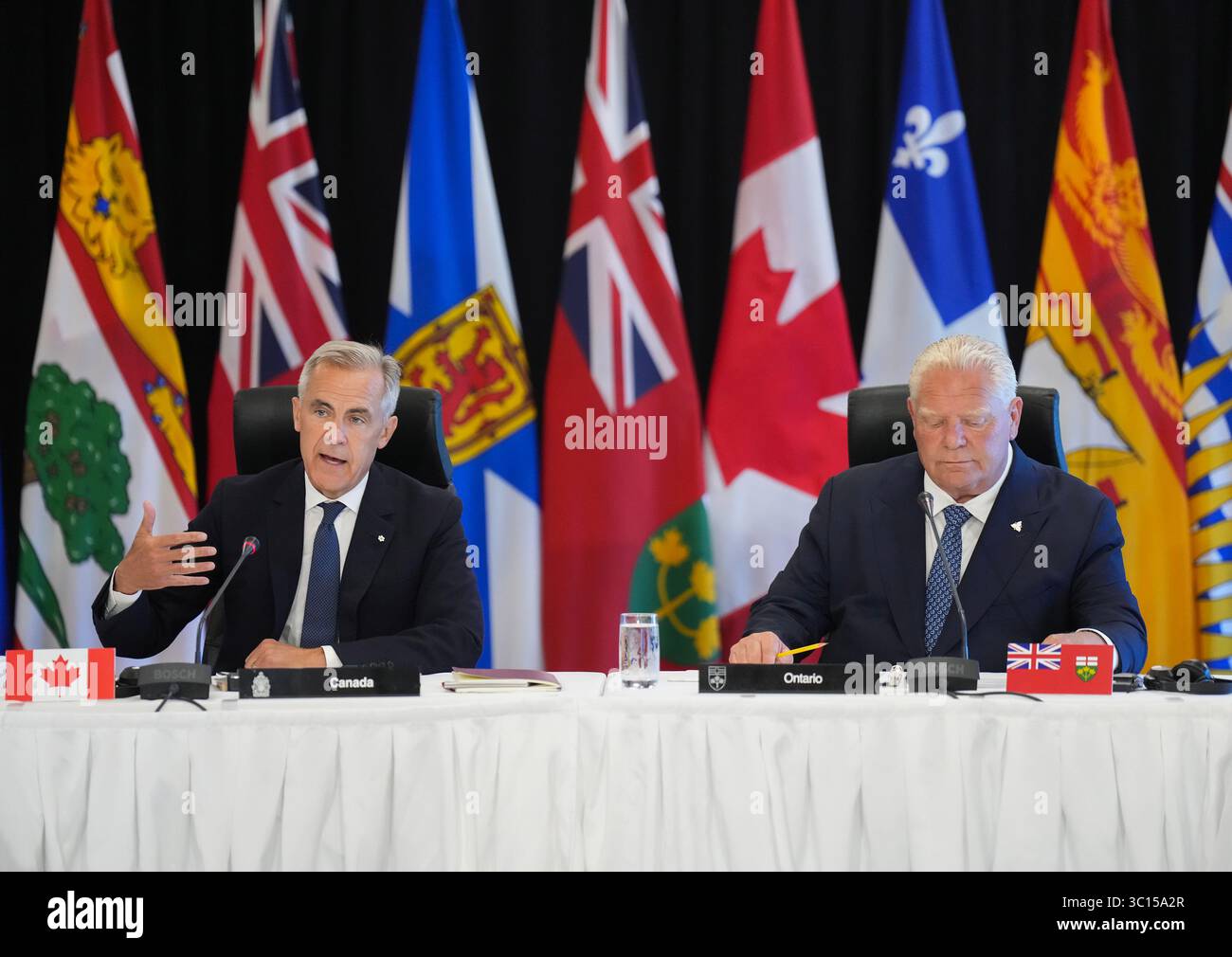Canadian Prime Minister Mark Carney, left, addresses the Premiers of Canada as Ontario Premier ...
