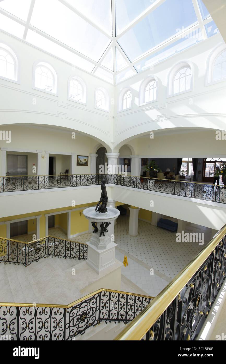 Elegant atrium with glass roof, wrought-iron railings and central ...