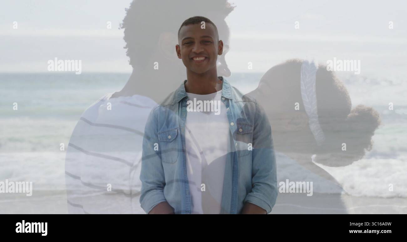 Smiling man standing at sandy beach edge, with ocean waves and ...