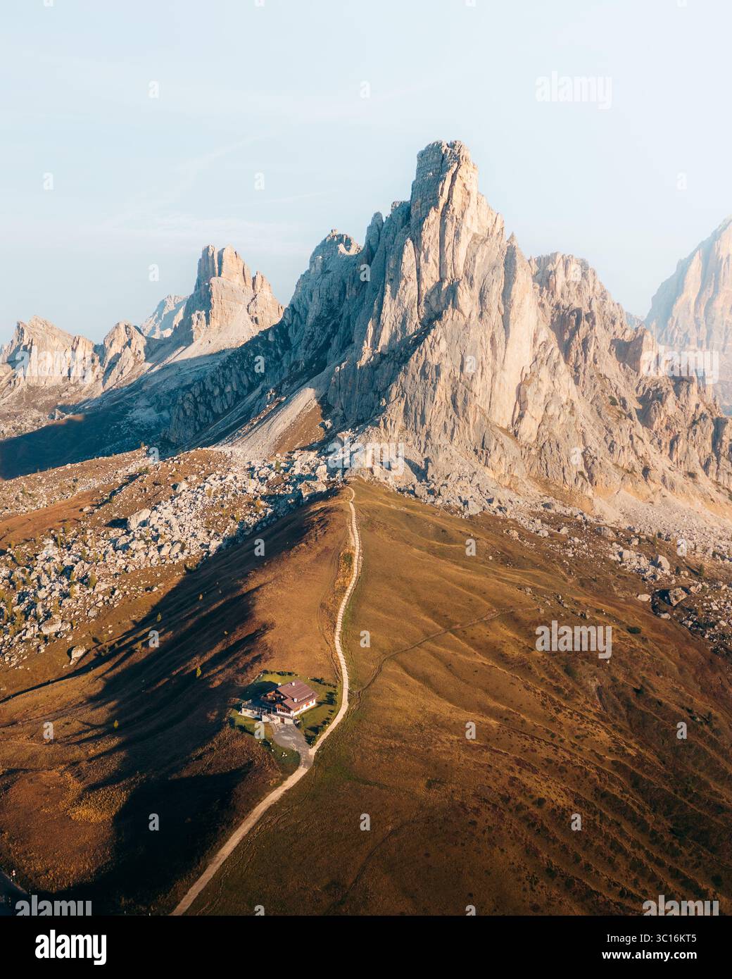 Aerial view of a lone building nestled along a path towards the jagged ...
