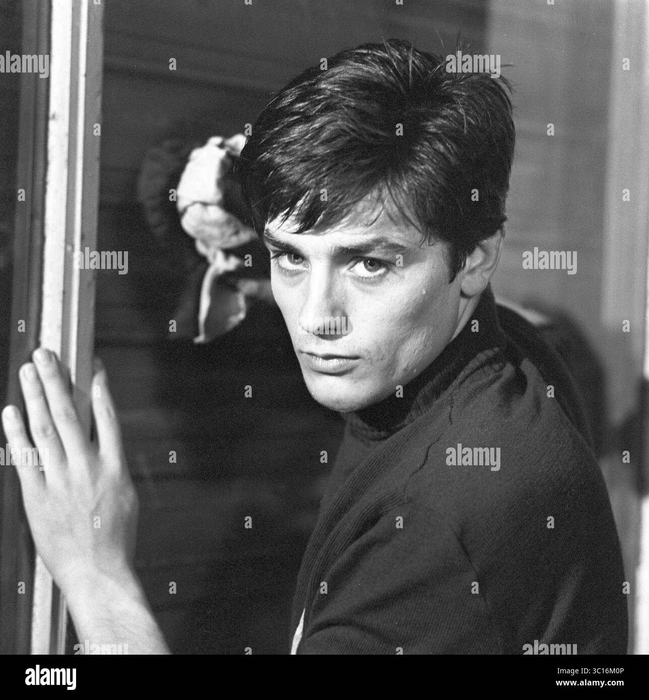 French actor Alain Delon acting leaned against a door in the film Rocco ...