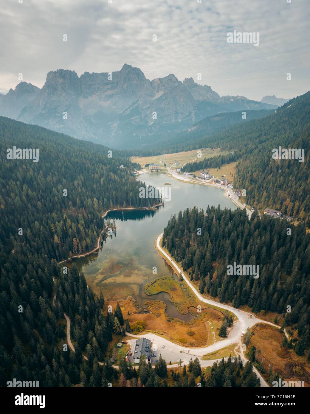 Aerial view of Lago di Misurina's dark waters reflecting the towering ...