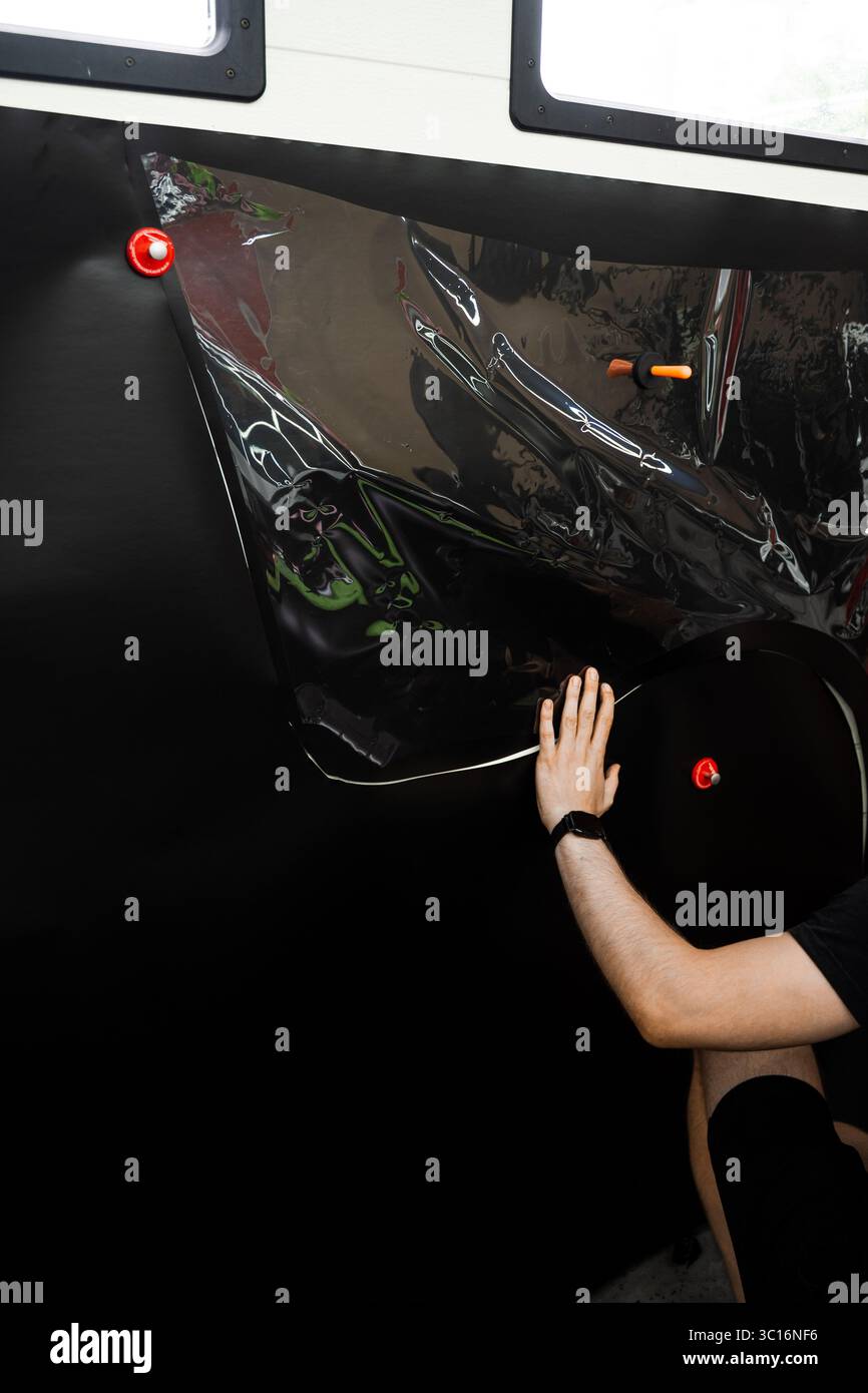 Vinyl wrap is manually cut using stencil over the film for precise ...