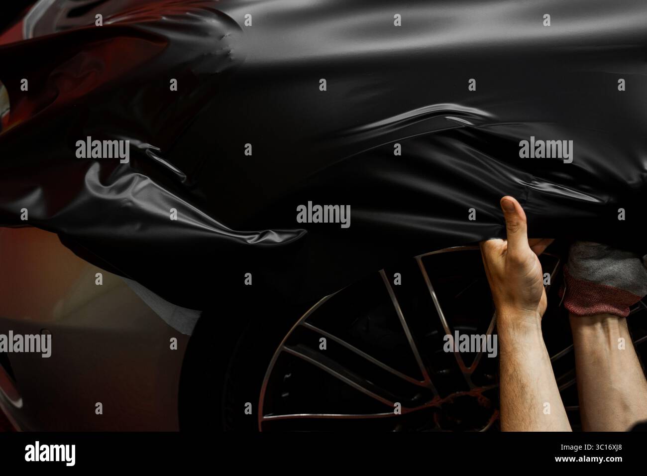 Matte black vinyl wrapping around car with smooth alignment over curves ...