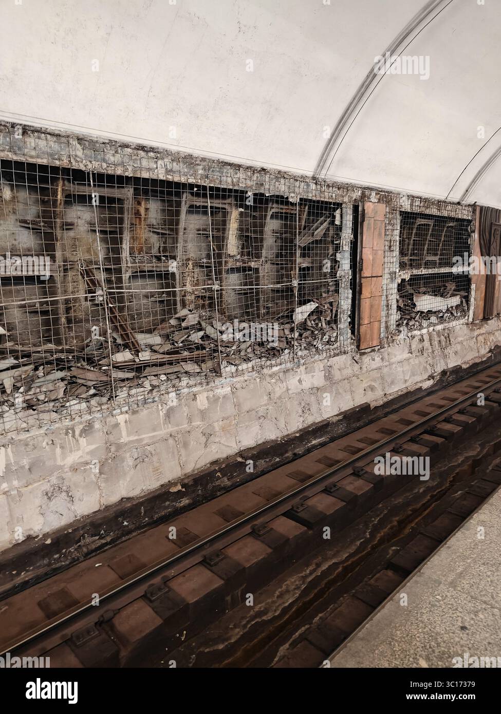 Abandoned subway station features exposed walls and debris near train ...