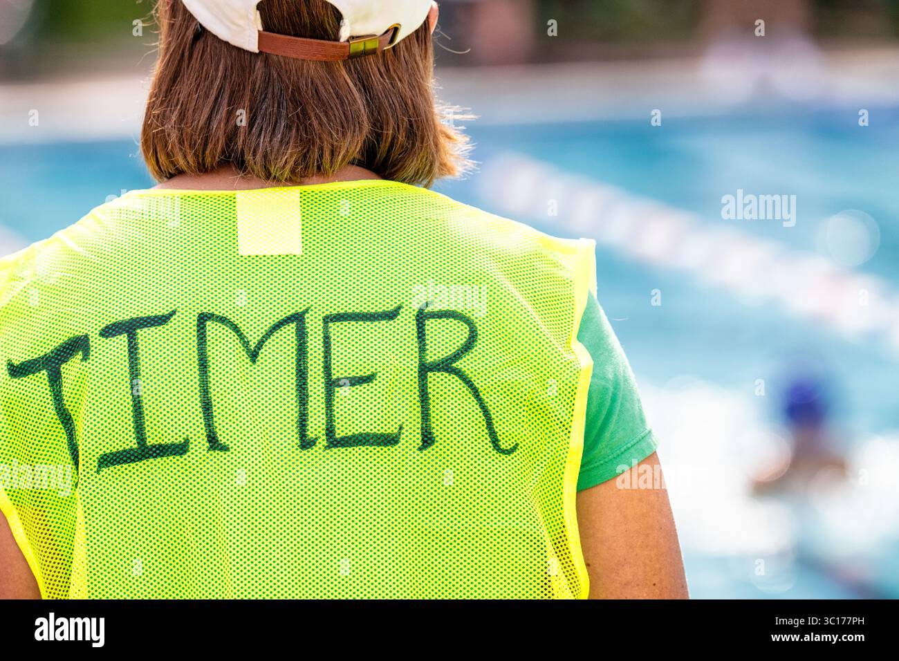 A parent volunteer timer, wearing a bright vest with "TIMER" written ...