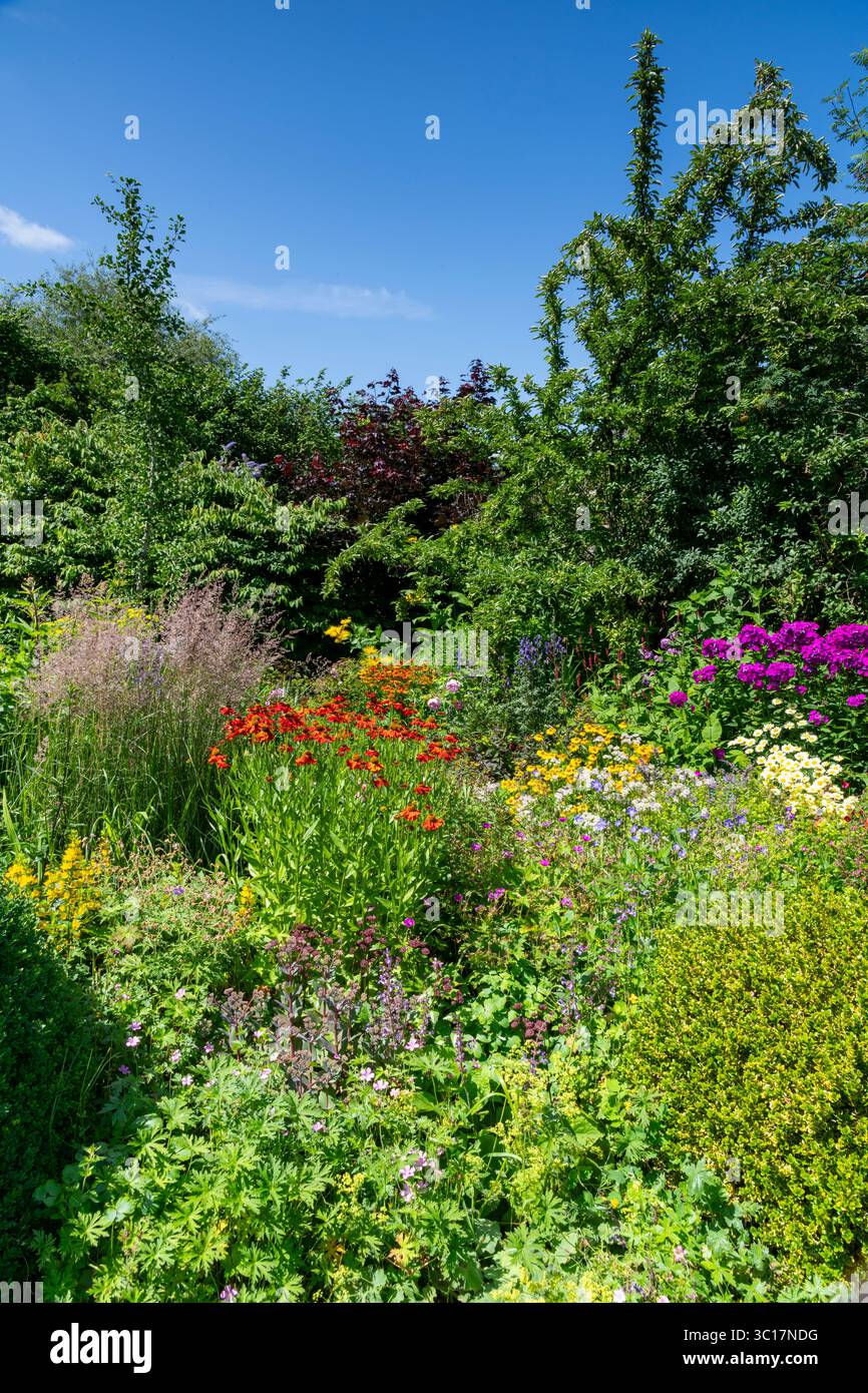 English country garden in full summer with masses of perennials in full ...