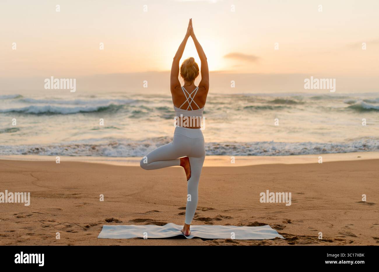 Female yogi balancing at beach during dawn, back view Stock Photo - Alamy