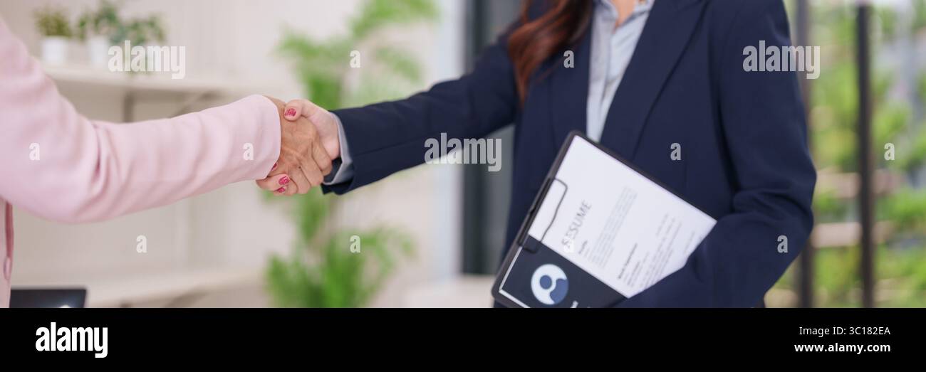 Two adult professional women shake hands sealing a new work connection ...
