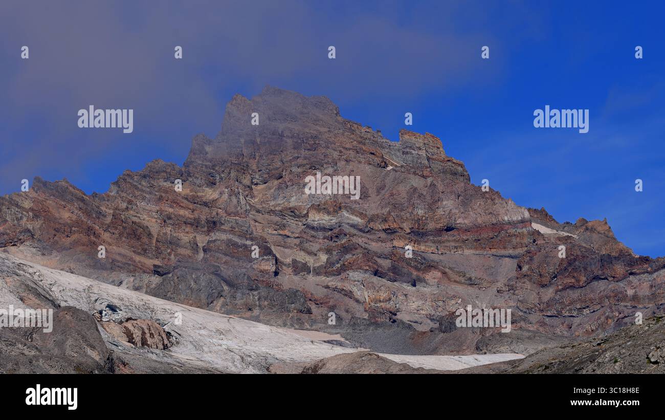 Jagged volcanic ridges and residual snowfields under a deep bold azure ...