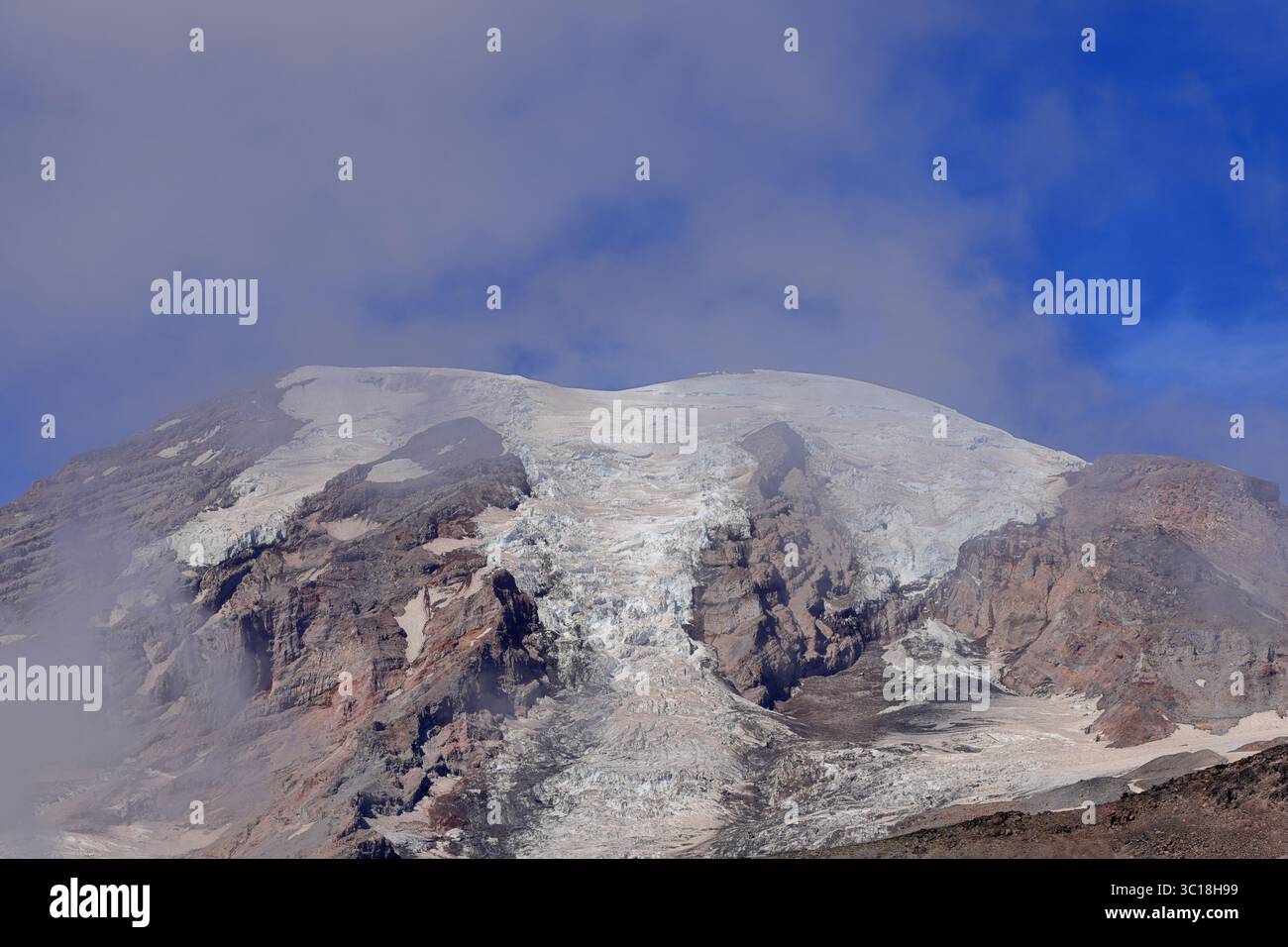Misty clouds swirl over rugged talus slopes and residual glacier ice ...