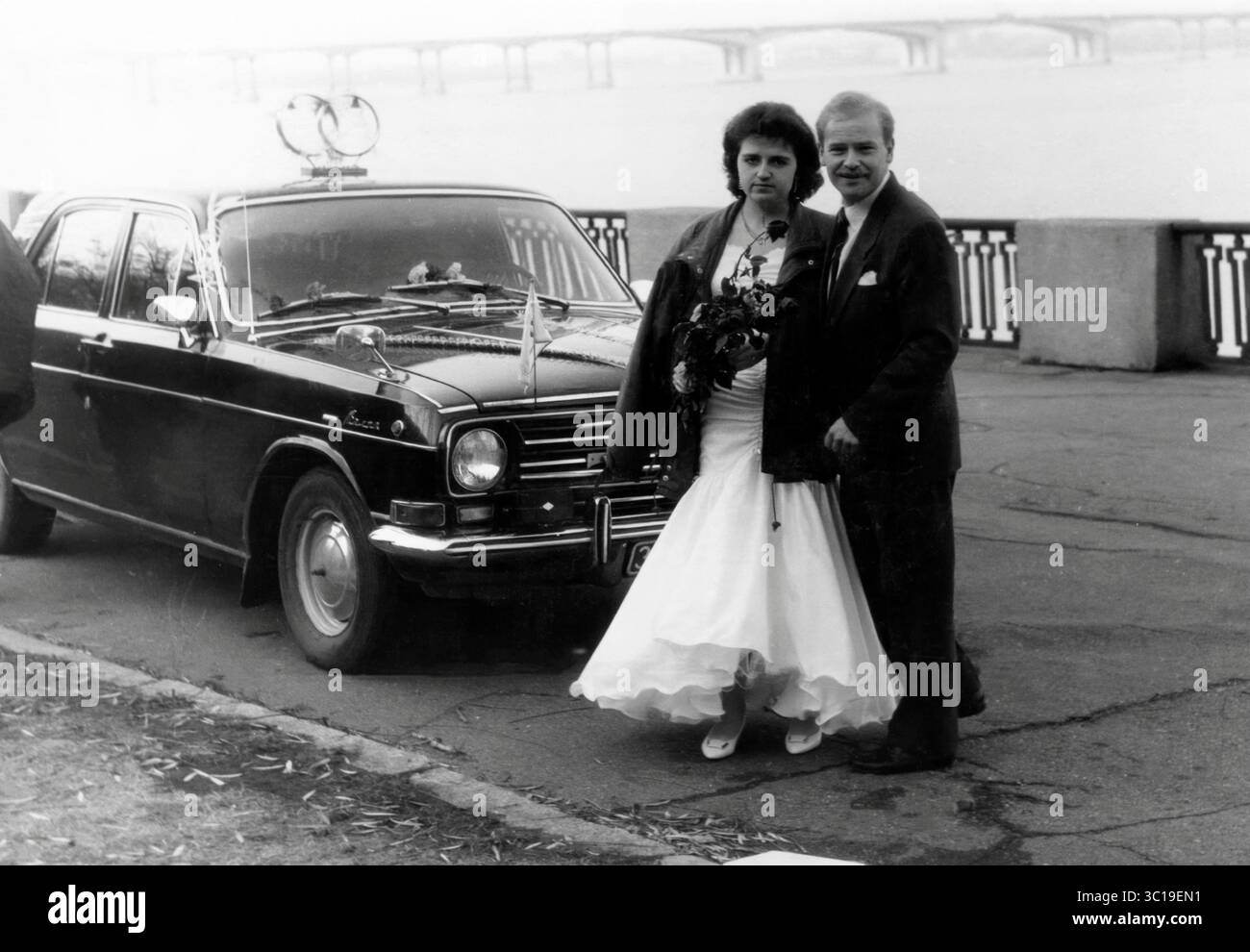 Vintage portrait of bride and groom on their wedding day near the car ...