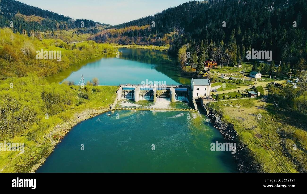 Aerial view of a hydroelectric dam in a forested valley. A serene ...