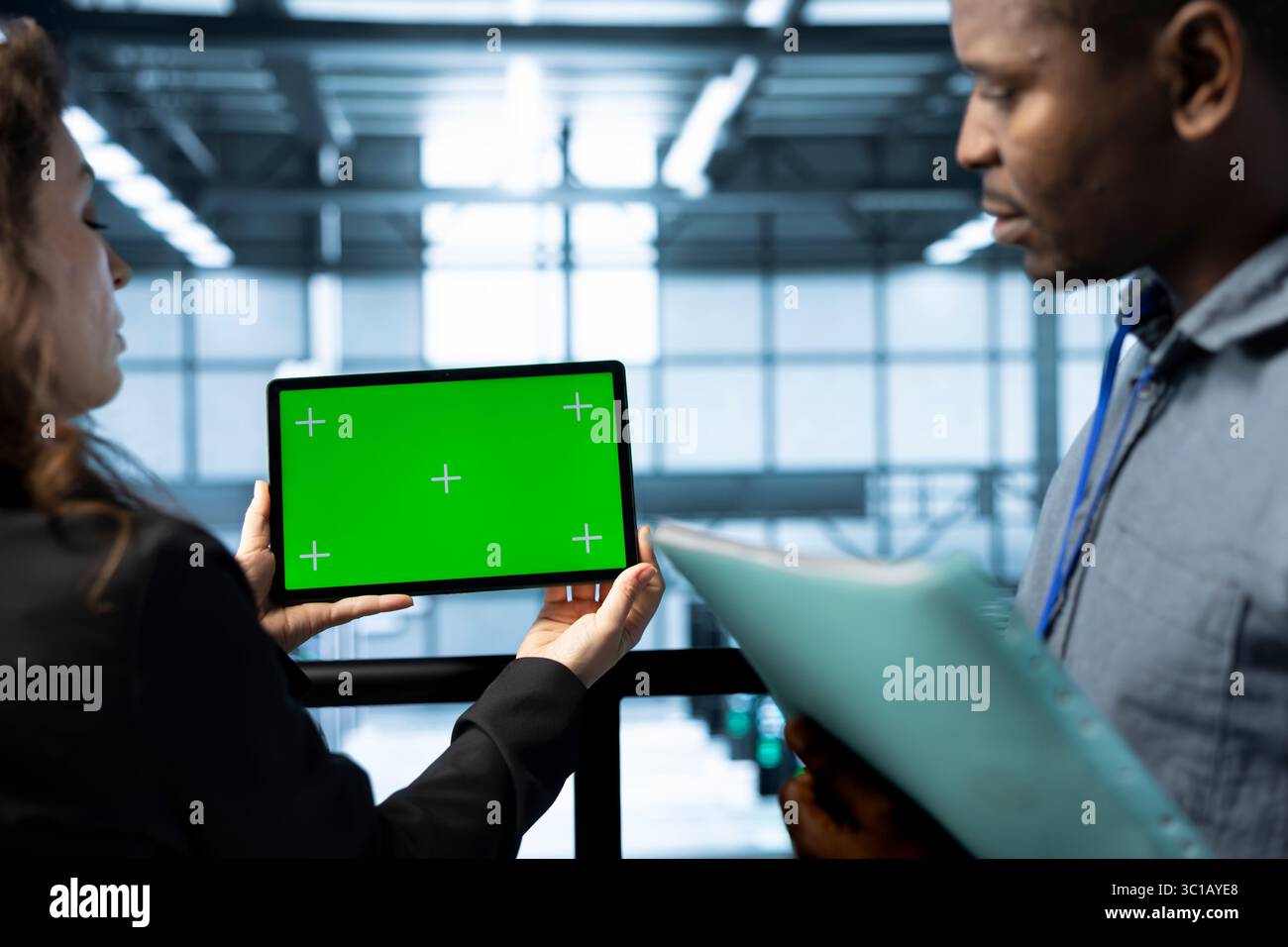 Team of admins in data center using green screen tablet, refining server virtualization ...
