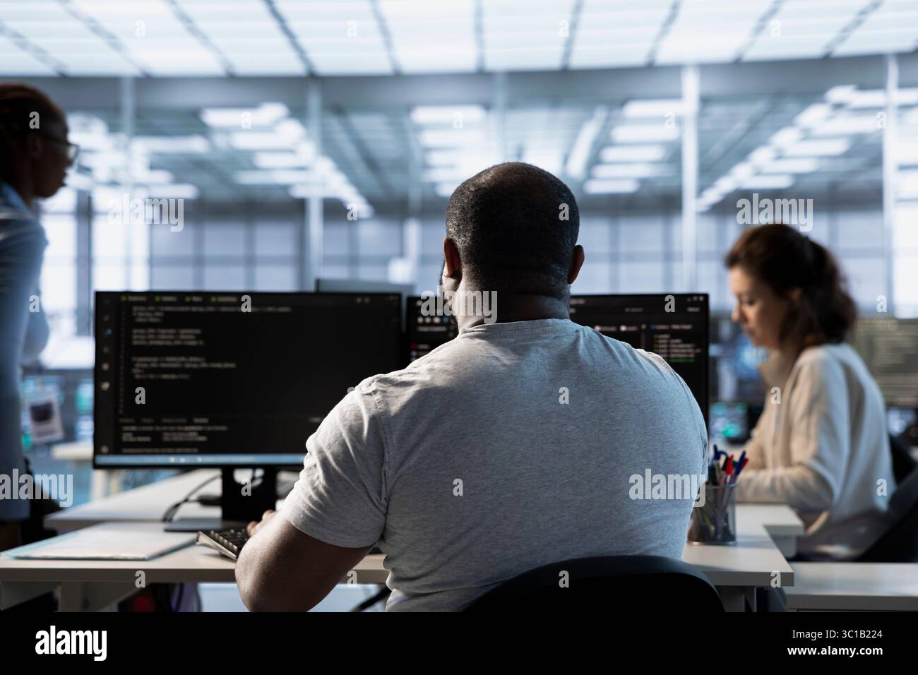 Admin in server hub next to colleagues tasked with protecting data ...