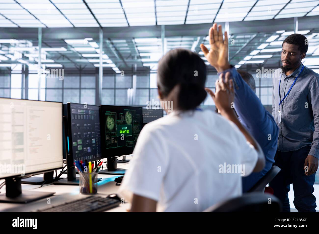 Engineer doing high five gesture with colleague after receiving access granted notification ...
