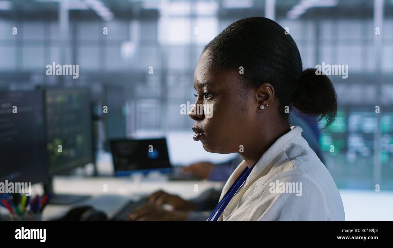 Close up of programmer in data center implementing AI predictive maintenance systems. Focus on ...