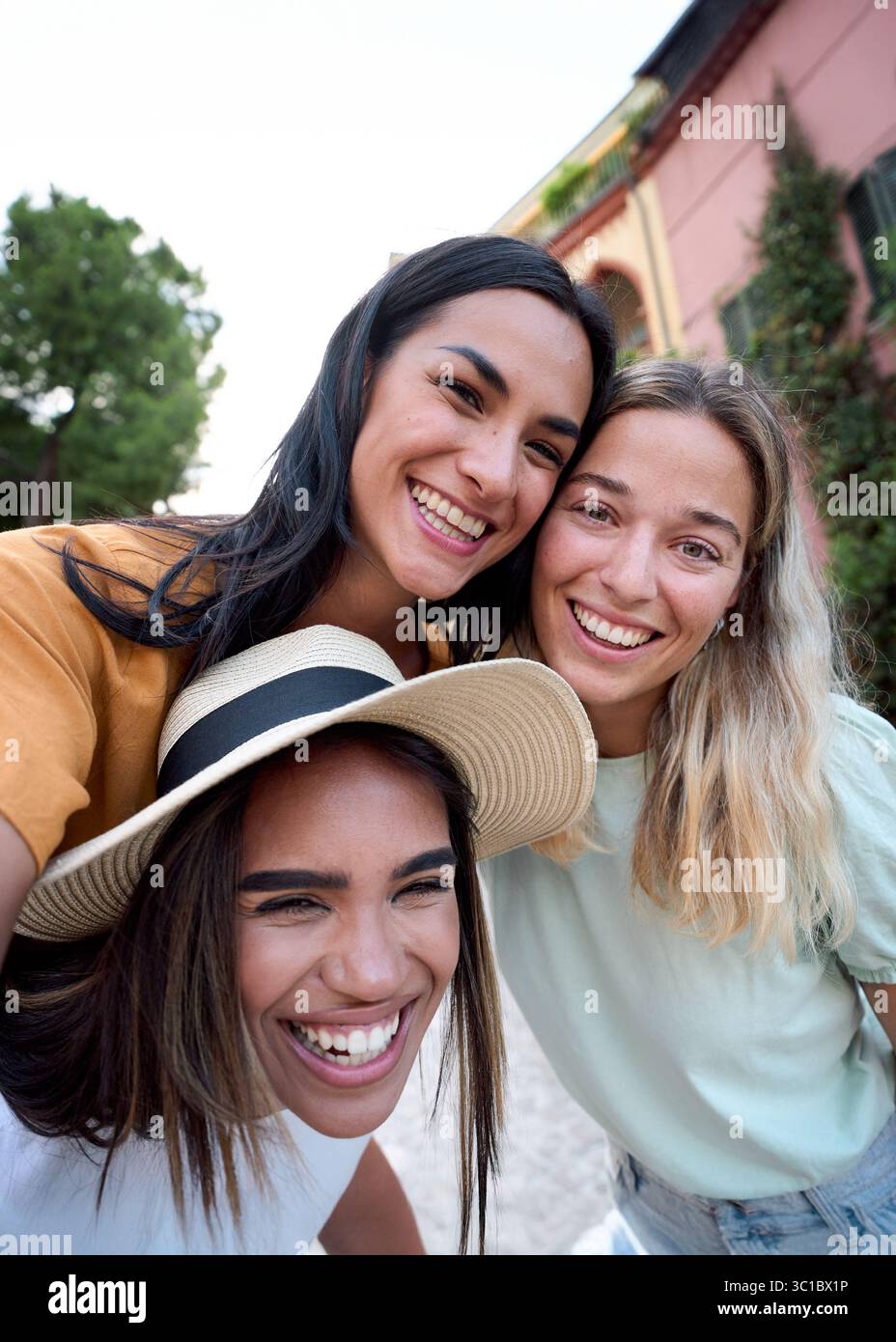 Three happy female friends laughing together on vacation Stock Photo ...
