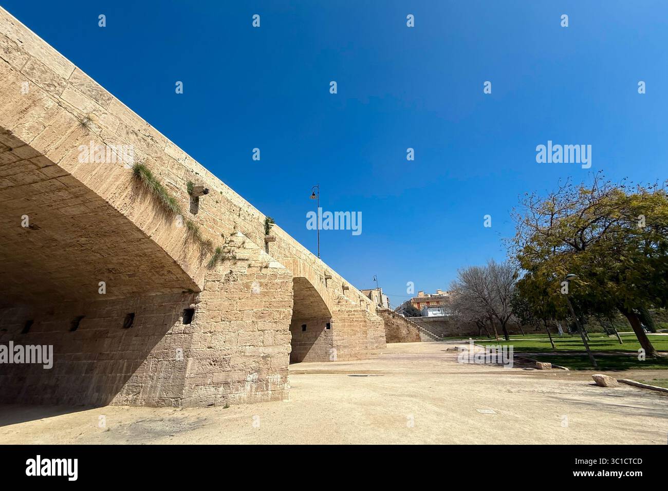 Sandstone arches of Puente del Real rise over the dry Turia riverbed in ...