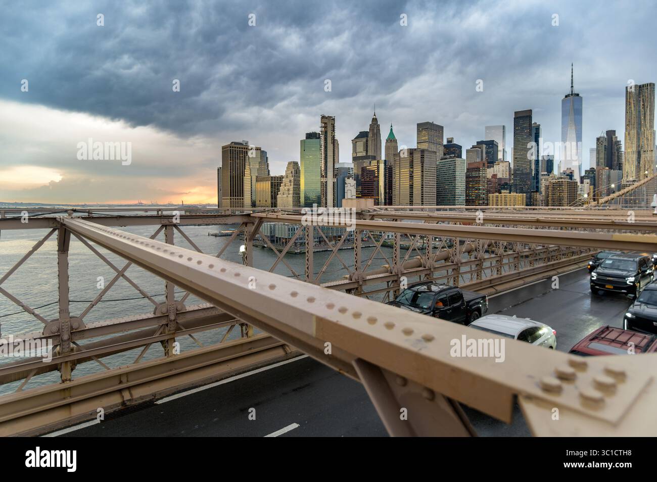 Traffic on Brooklyn Bridge with storm clouds over Manhattan Financial ...