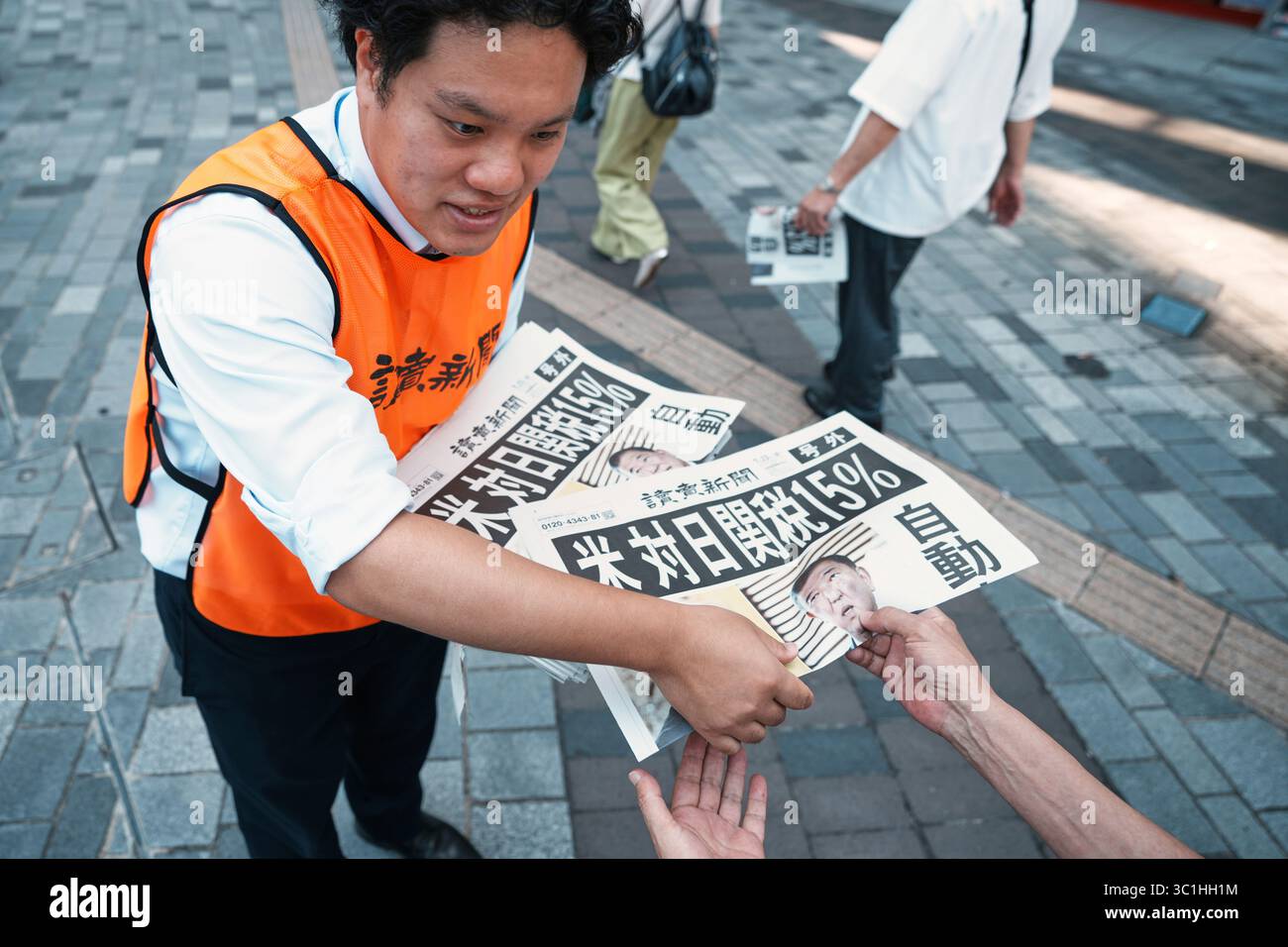 A staff member distributes an extra edition of the Yomiuri Shimbun ...