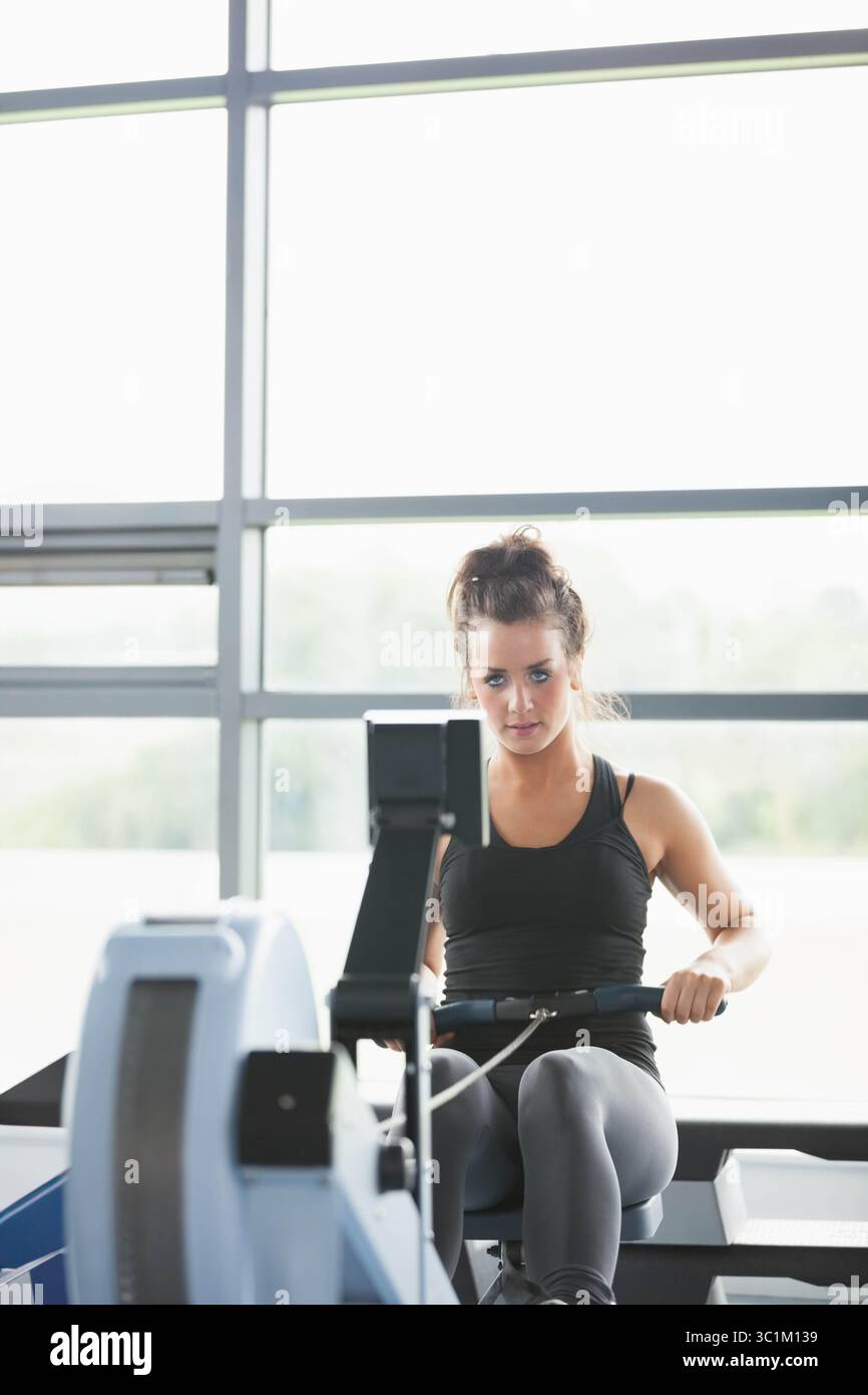 Woman pulling rowing machine handle hi-res stock photography and images ...