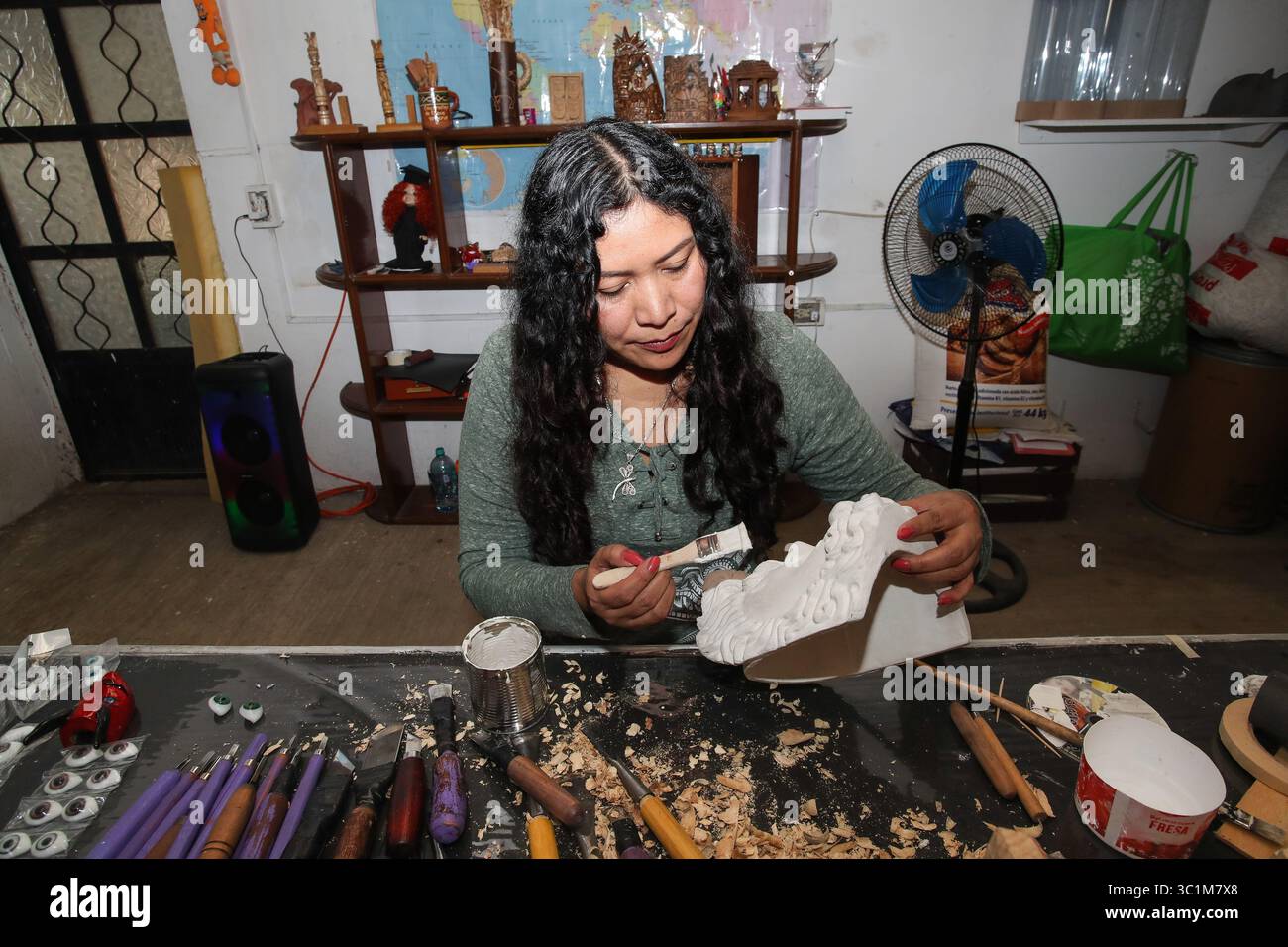 Artisan Elsa Padilla puts down a base of paint on a wooden mask during ...
