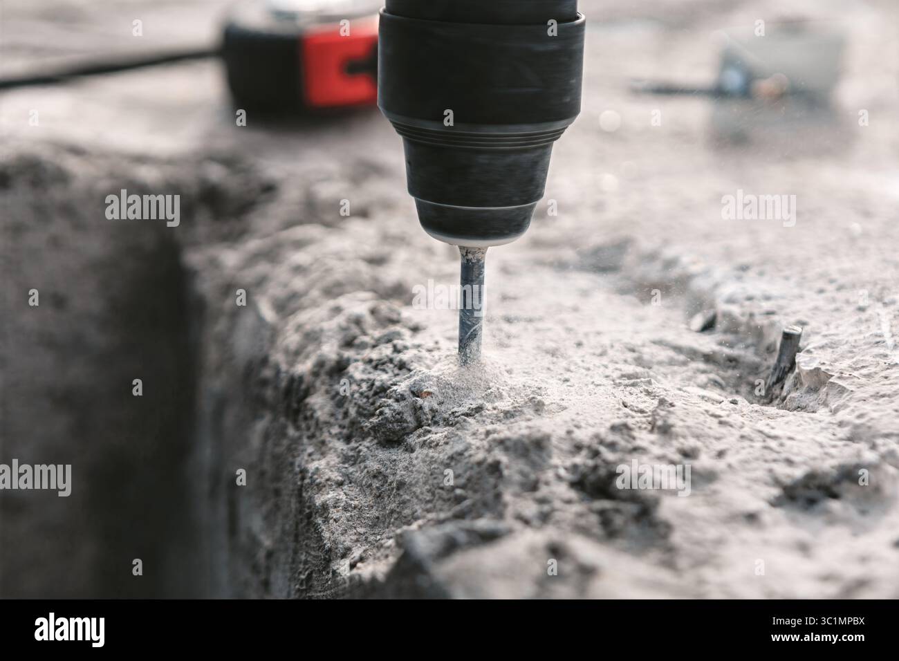 Concrete foundation is being reinforced with a powerful impact drill ...