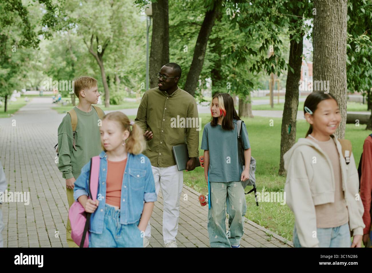 Diverse Group of Children and Black Male Teacher Walking Together in ...