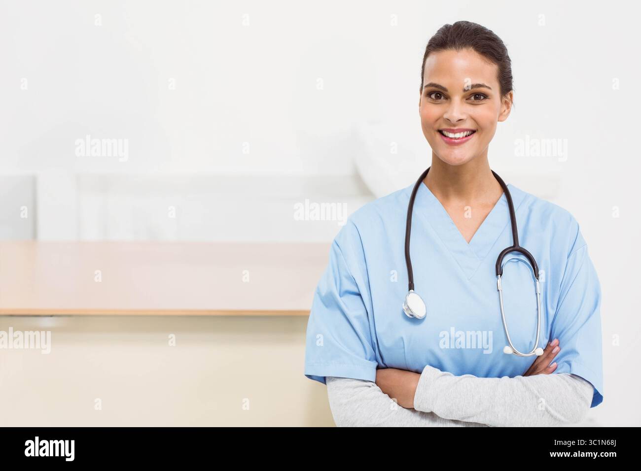 Adult female nurse standing at reception counter in scrubs with ...