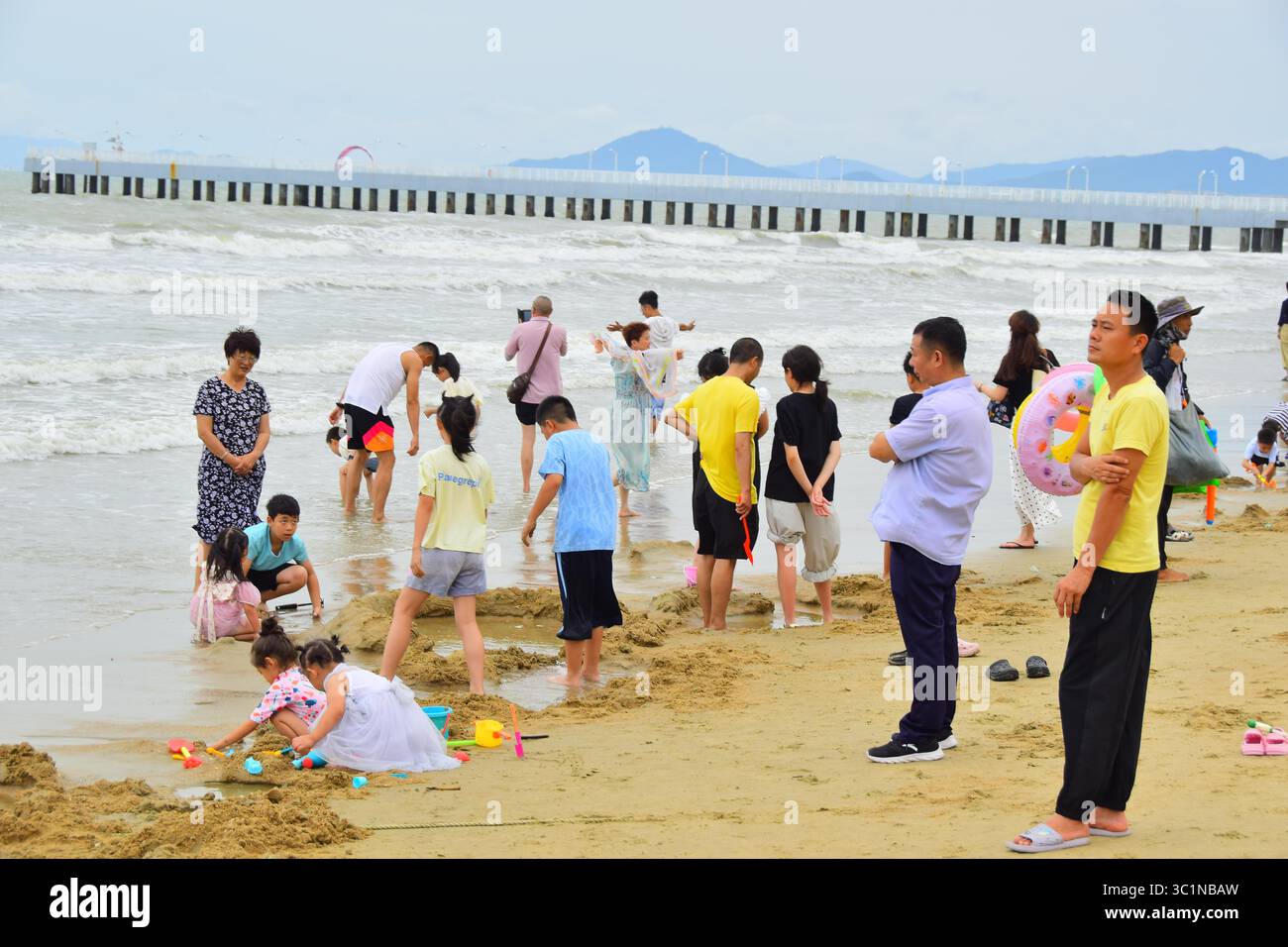Tourists play at the seaside in Sanya City, southernmost China's Hainan ...