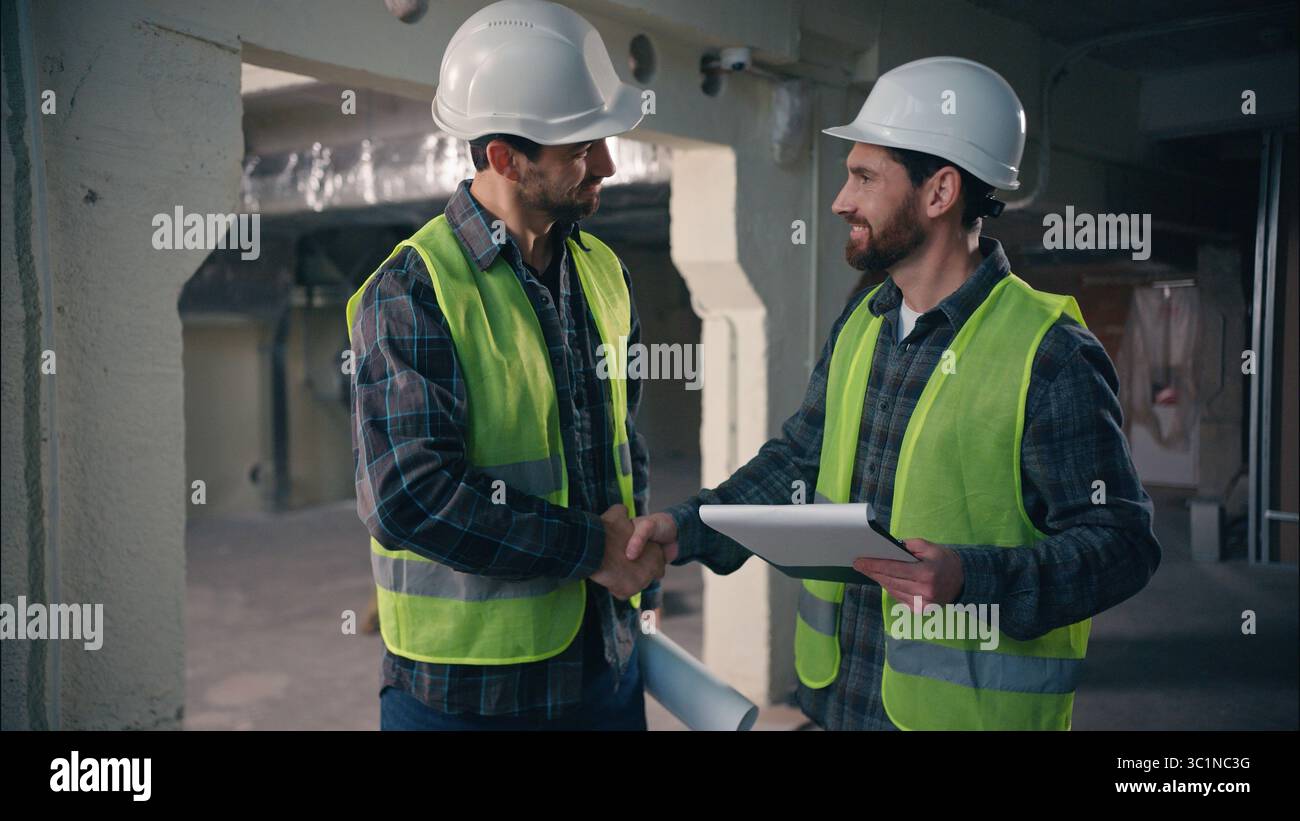 Glad Caucasian workers men guys holding draft papers mechanics working project architects plan ...