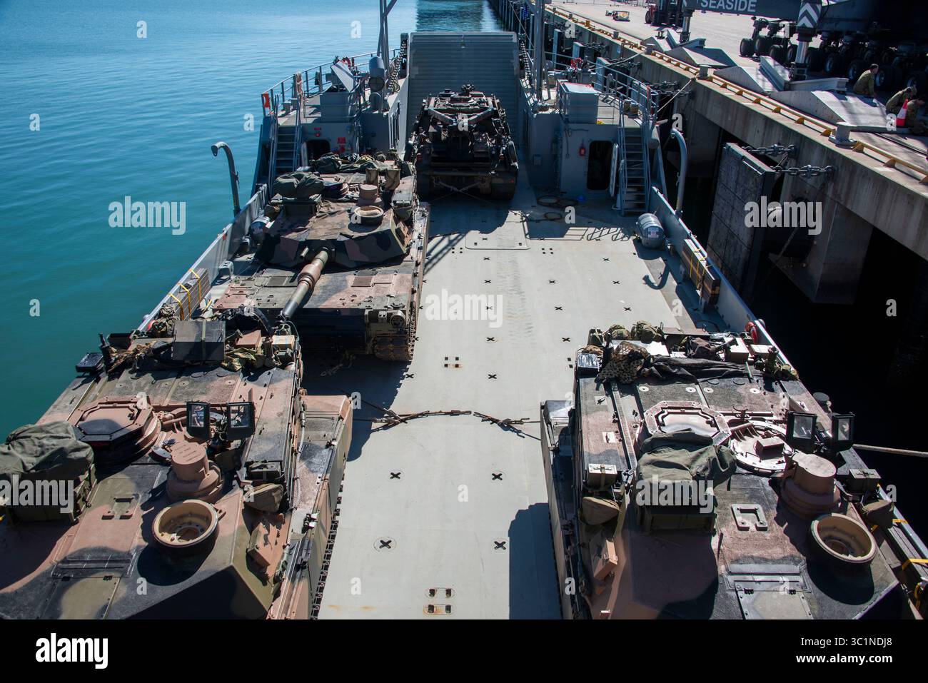 Australian tanks aboard a U.S. transportation ship are loaded on the ...