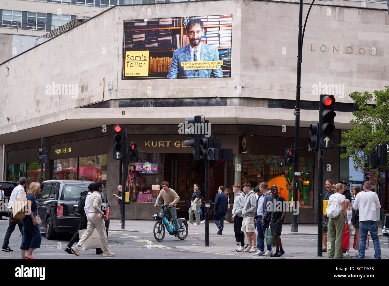 A digital ad for Sam's Tailor of Hong Kong is seen above shoppers on ...