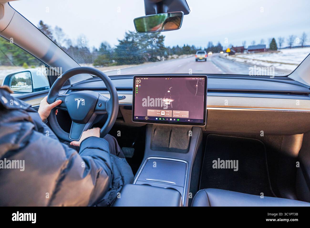 Woman driver holding steering wheel of Tesla Model Y electric car with ...