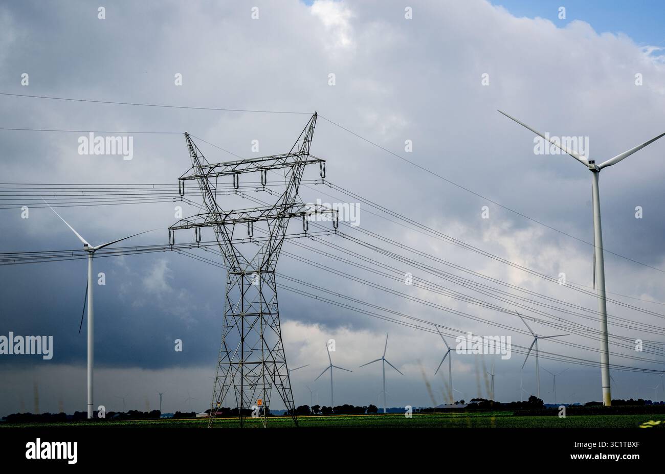 DRONTEN - Windmills along the road and high-voltage pylons in the ...