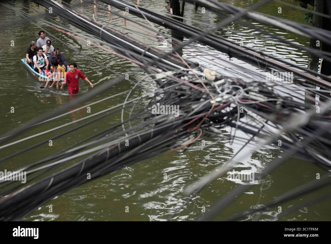 Residents are ferried by a small boat as they negotiate flood water ...