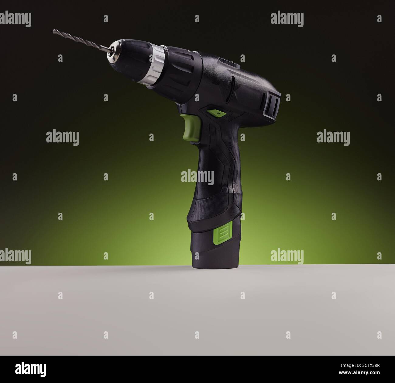A black and green cordless drill is prominently displayed against a ...