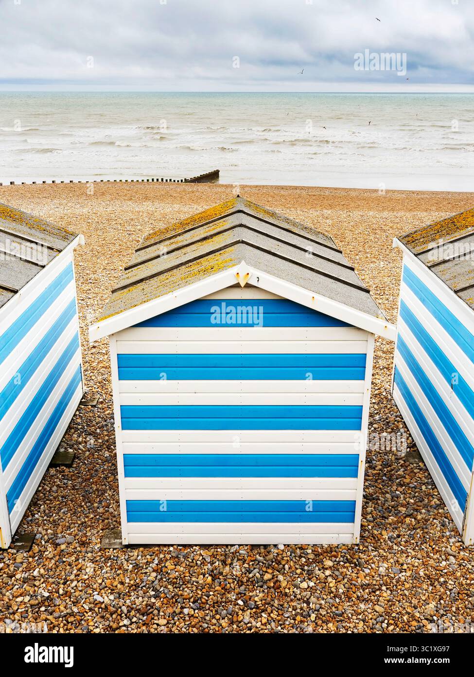 Blue and white striped beach huts on the shingle at Hastings East ...